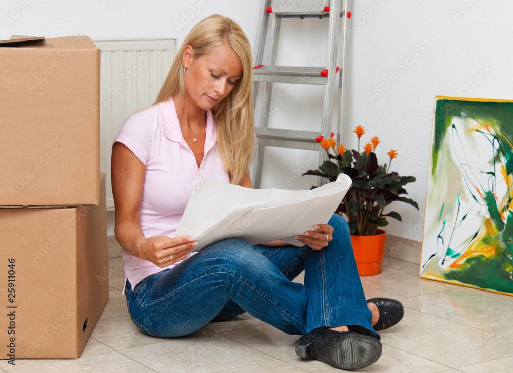 Frau mit Plan in neuer Wohnung beim Umzug. Stock Photo | Adobe Stock
