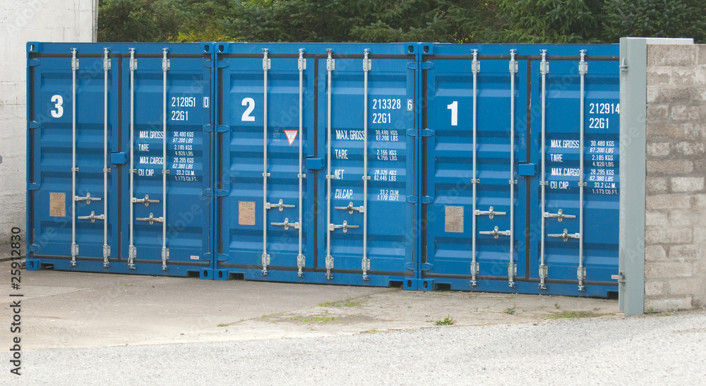 blue shipping containers lined up. Stock Photo | Adobe Stock