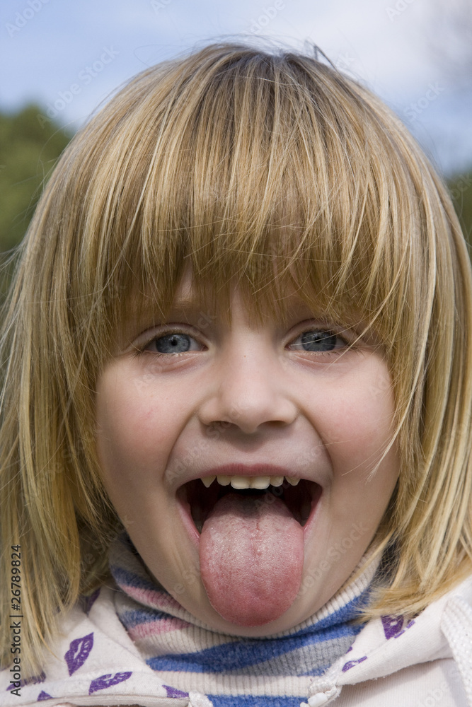 Little girl is showing a tongue Stock Photo | Adobe Stock Little girl is showing a tongue Stock Photo | Adobe Stock