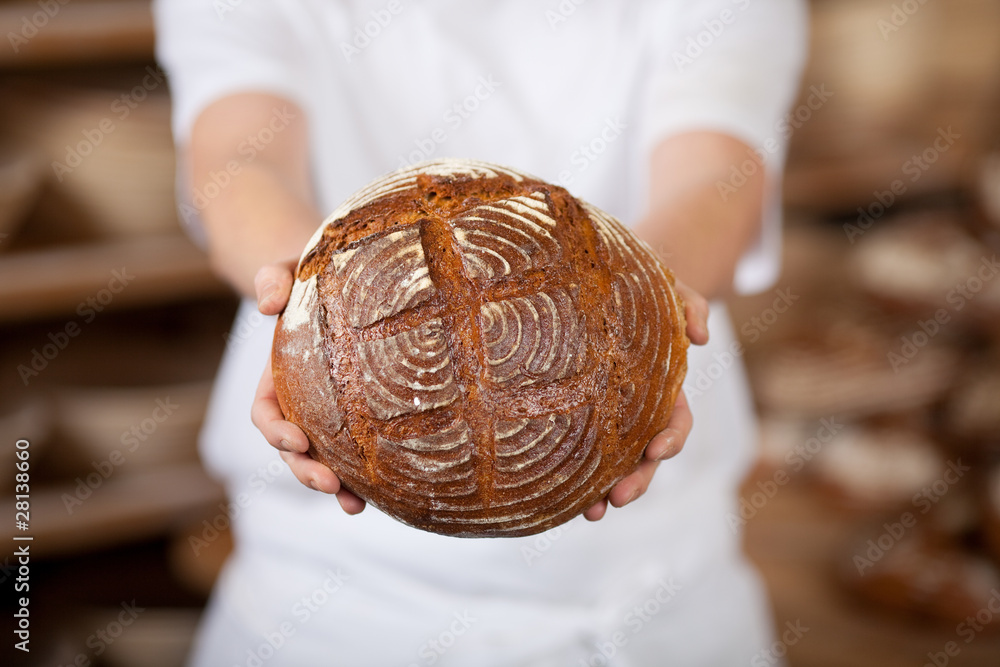 bäcker zeigt rundes brot Stock-Foto | Adobe Stock