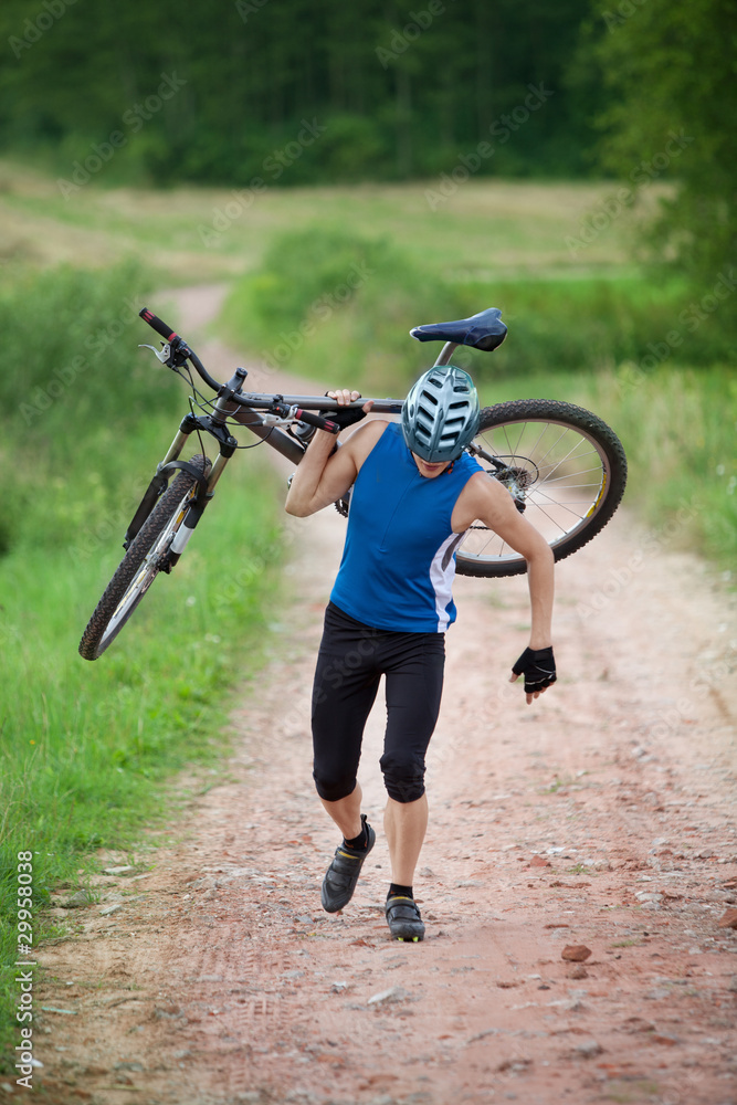 Cyclist carrying bicycle Stock Photo | Adobe Stock