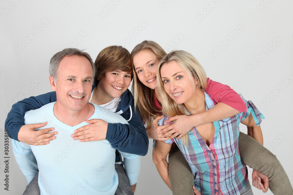 Happy parents holding children on their back Photos | Adobe Stock