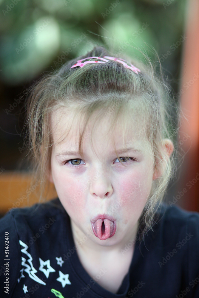 Mädchen streckt Zunge raus Stock-Foto | Adobe Stock