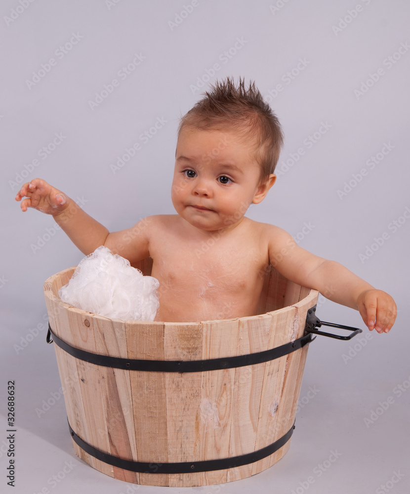 enfant prenant son bain dans un baquet en bois Photos | Adobe Stock