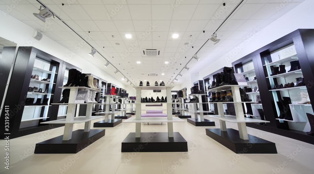 Black selves with many boots and shoes into large shoe store Stock ...