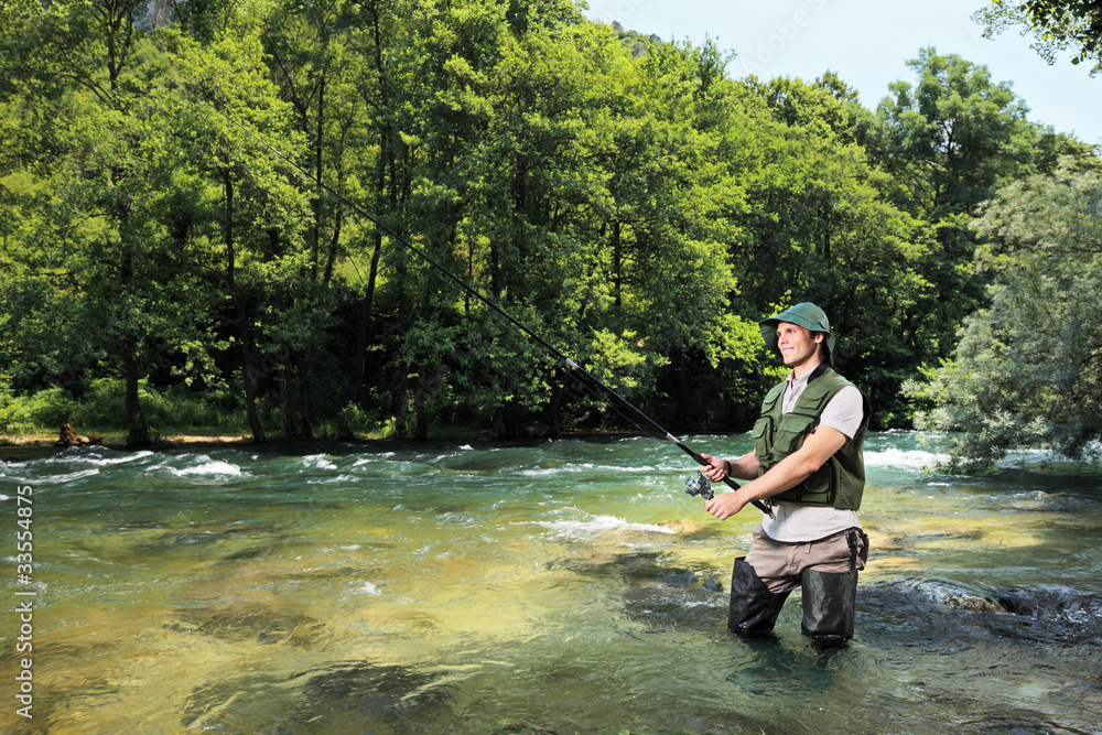 Fisherman fishing on a river with forest in the background Stock Photo ...