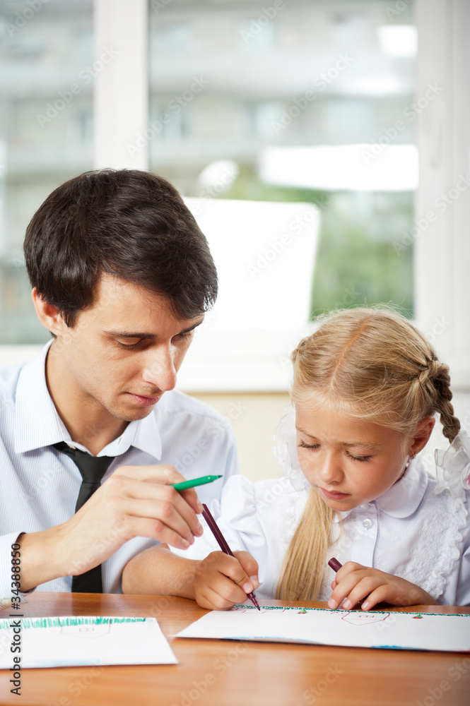 Teacher helping elementary school pupils with their tasks Stock Photo ...
