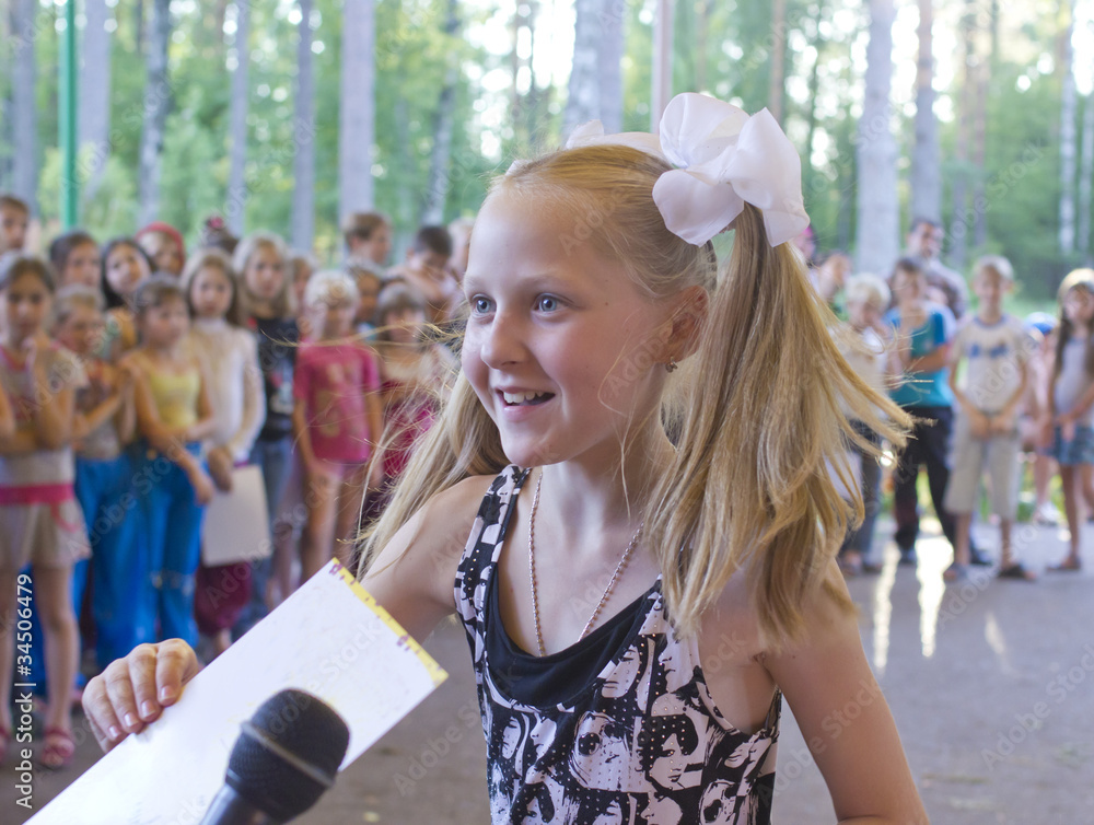 Little girl gives an interview in front of group of children Stock ...