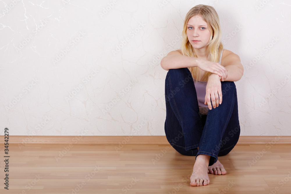 Woman Sitting Against Wall