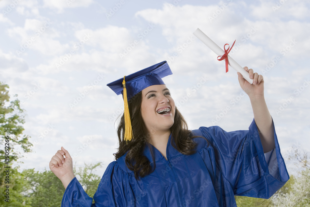 Hispanic teenage girl in graduation cap and gown holding diploma Stock ...