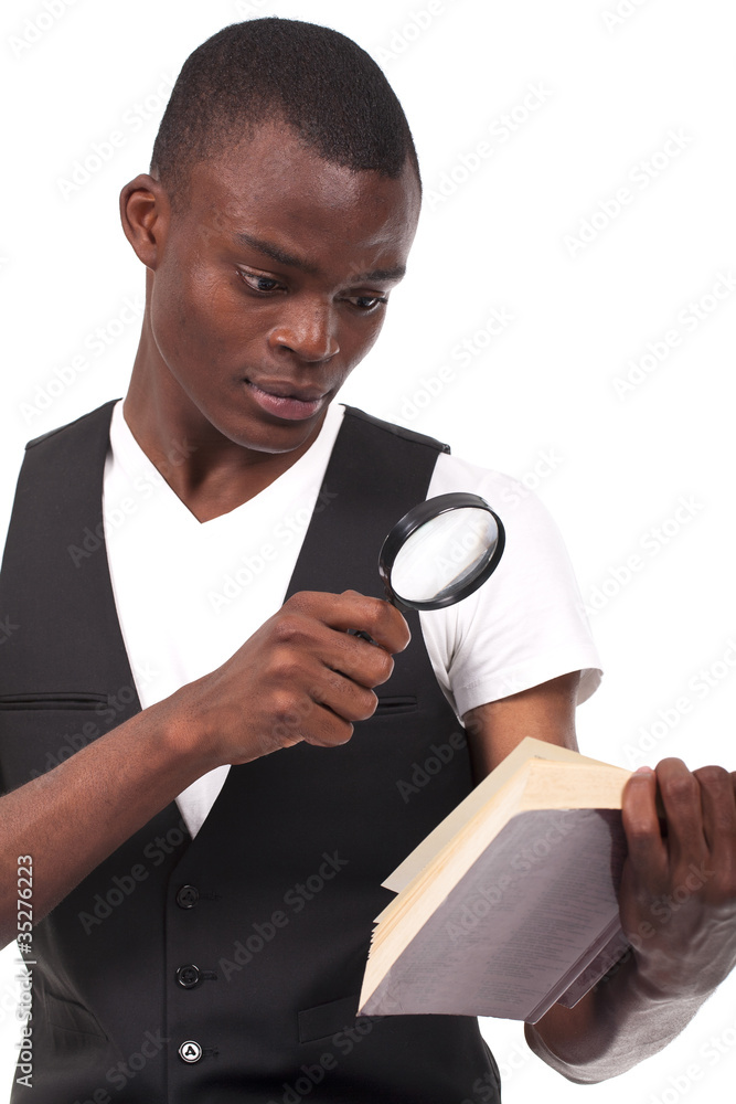 black man holding a magnifying glass and reading a book Stock Photo ...