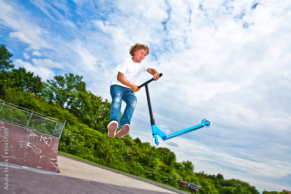 boy with scooter is going airborne Stock Photo | Adobe Stock