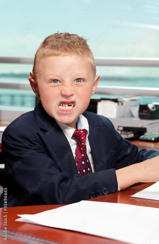 Cute boy with angry face in business attire in an office Stock Photo ...