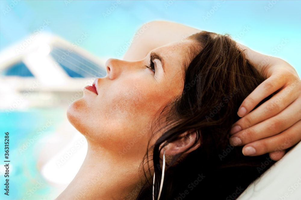 Pretty young woman lying on beach at modern resort. Hotel buildi Stock ...