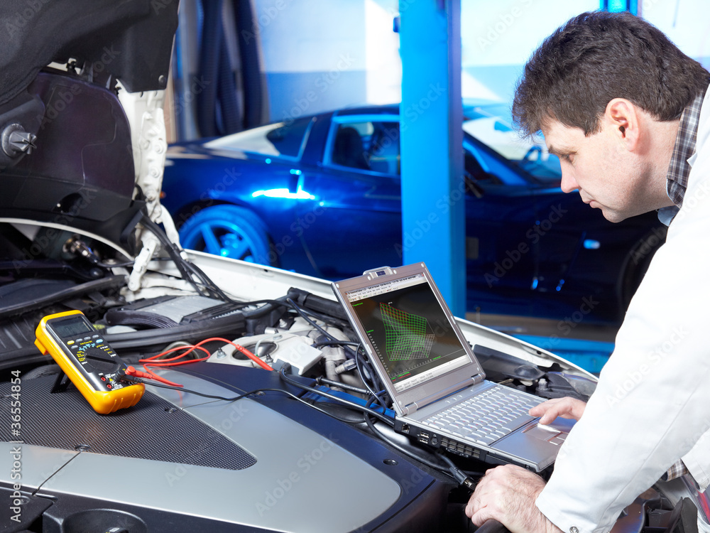 Motor mechanic is tuning and checking the engine of a car Stock Photo ...