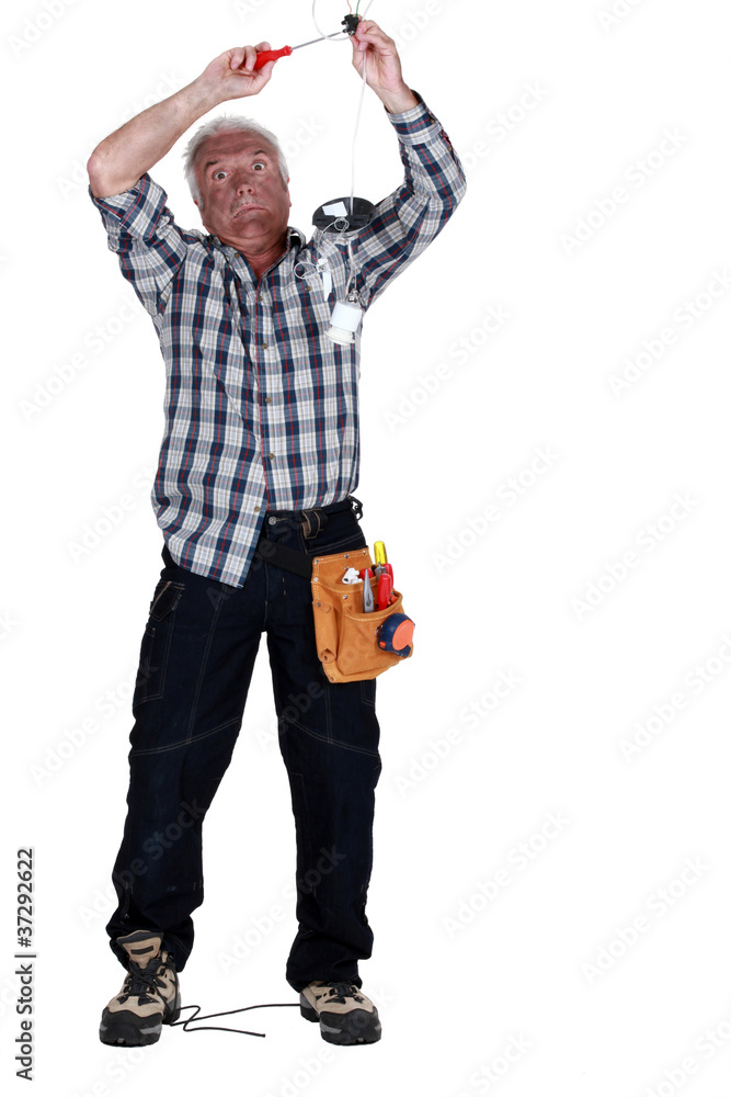Electrocuted man fixing a light fixture Stock Photo | Adobe Stock