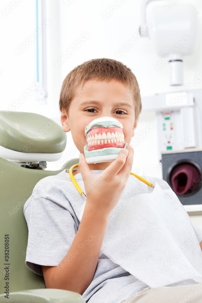 Kind beim Zahnarzt hält Gebiss Stock Photo | Adobe Stock