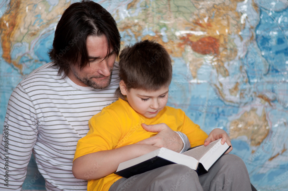 Dad and son reading a book on a map of the world Stock Photo | Adobe Stock