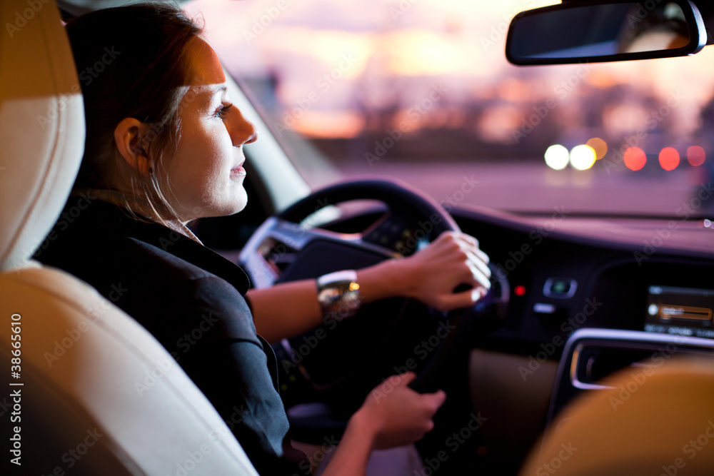 Driving a car at night - young woman driving her modern car Stock Photo ...