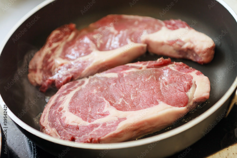 beef steak in a frying pan Stock Photo | Adobe Stock