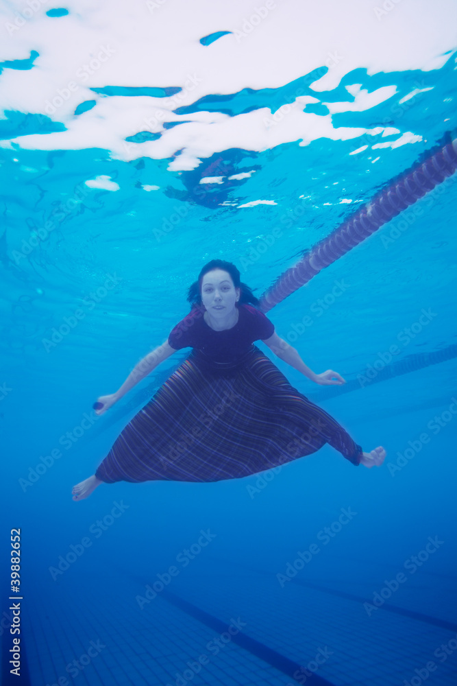 Woman swimming in the pool in clothes Stock Photo | Adobe Stock