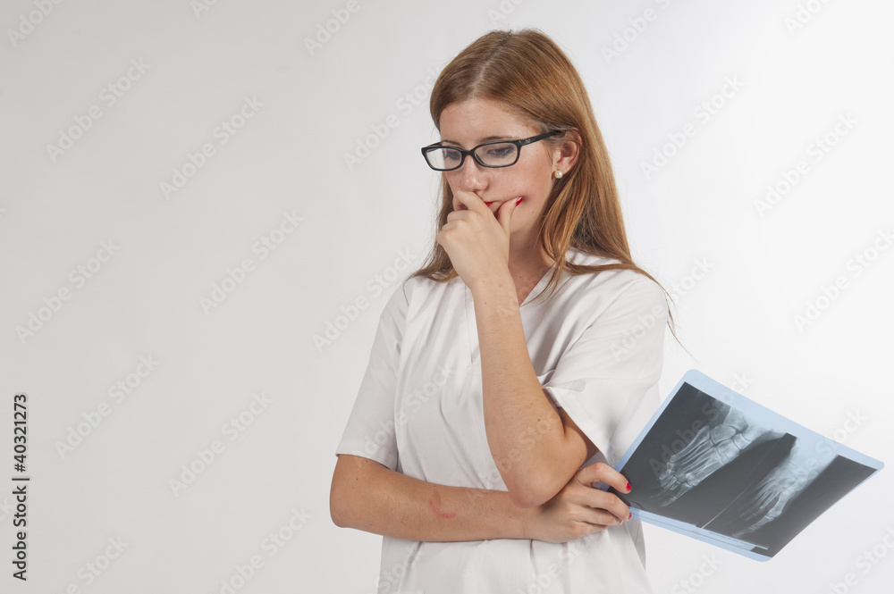 Doctora joven pensando en un diagnóstico. foto de Stock | Adobe Stock