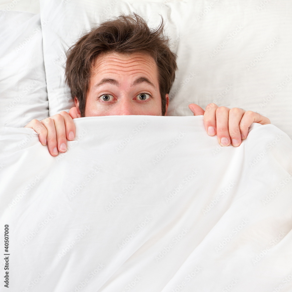 Scared man hiding in bed Stock-Foto | Adobe Stock