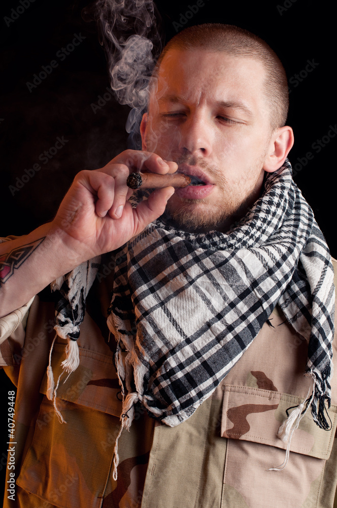 Soldier in combat uniform smoking cigar, dark background Stock Photo ...