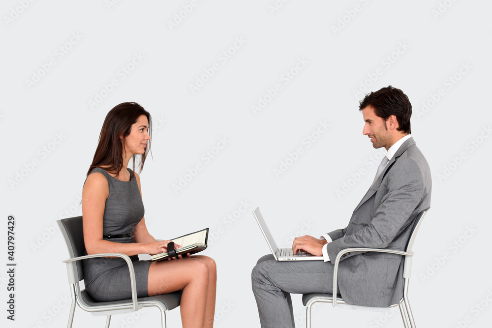 Business people sitting face to face on grey background Stock Photo ...