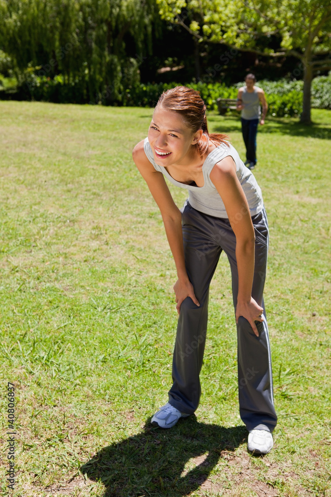 woman bending over while man is walking in the background Photos ...