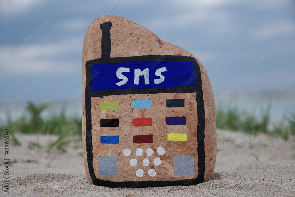 stone mobile phone on the sand and sms Stock Photo | Adobe Stock