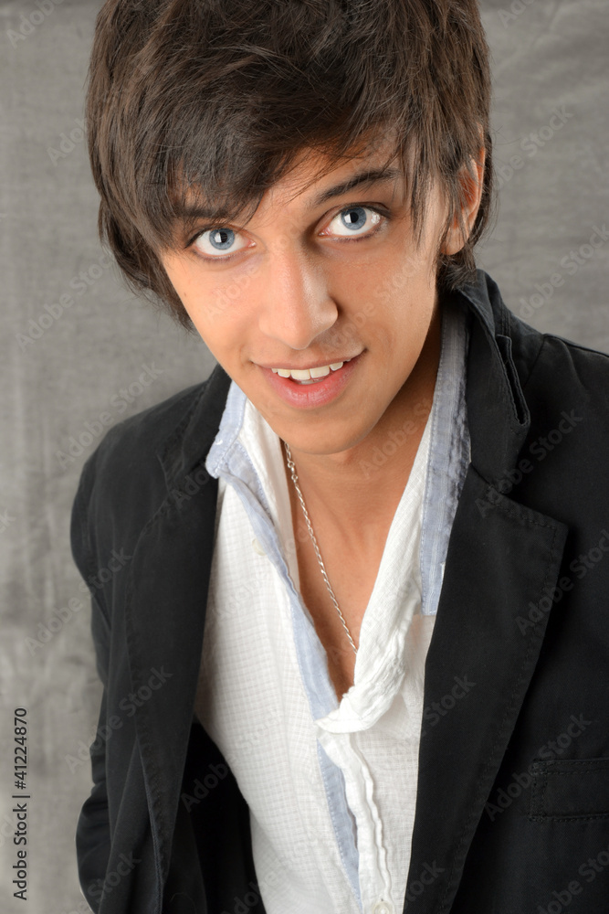 Portrait d'un jeune homme brun aux yeux bleus Photos | Adobe Stock