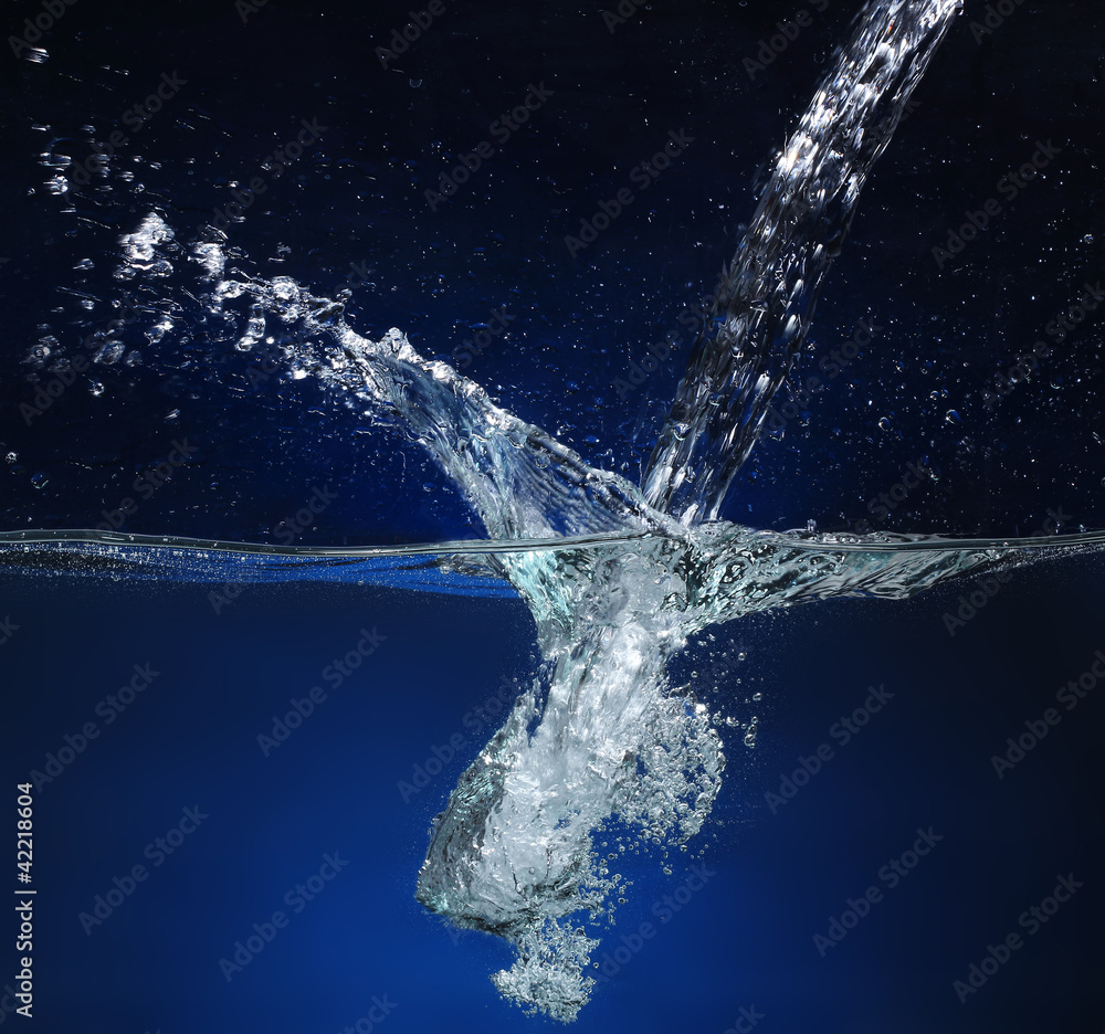 Pouring water. Splash image on a blue background Stock Photo | Adobe Stock