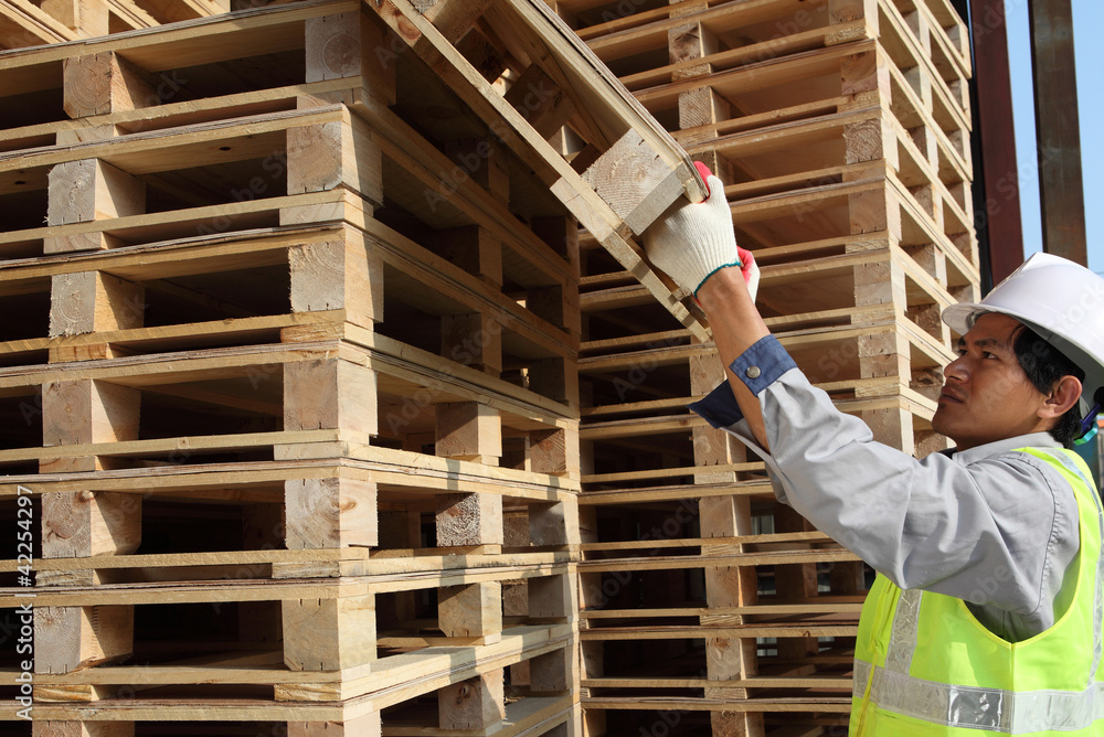 worker man arranging pallets in a warehouse Stock Photo | Adobe Stock