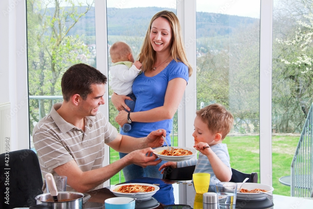 Junge Familie beim Essen Stock-Foto | Adobe Stock