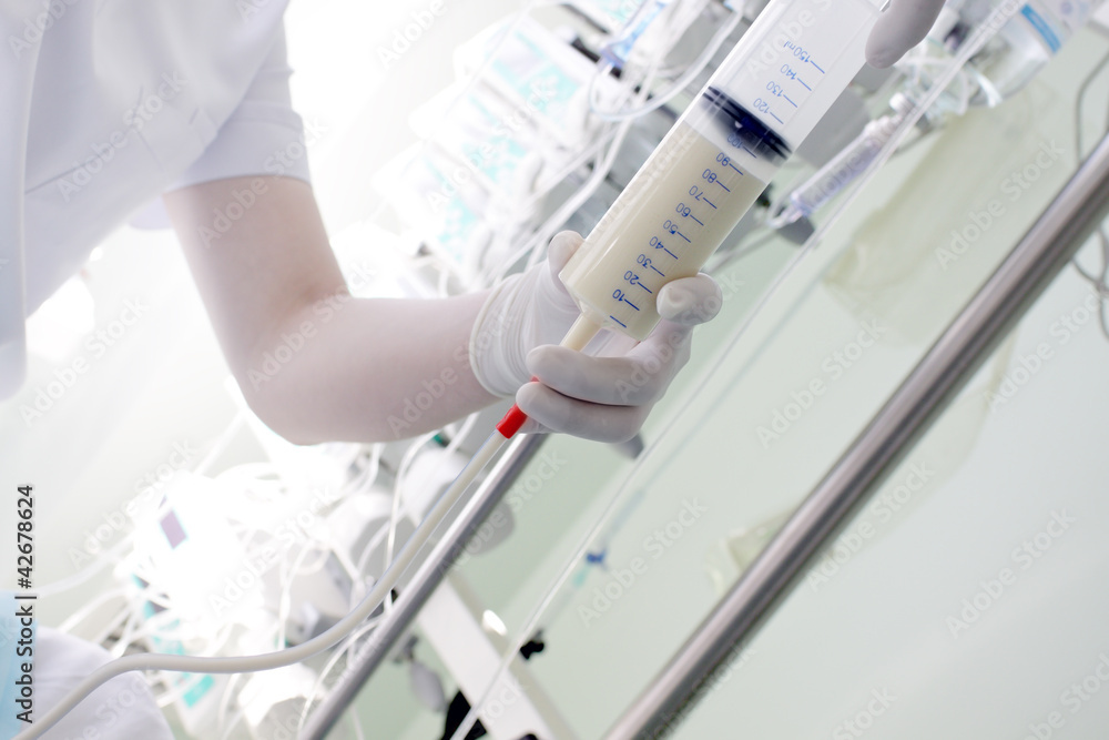 Fotografia do Stock: Nurse conducts tube feeding in the ICU | Adobe Stock