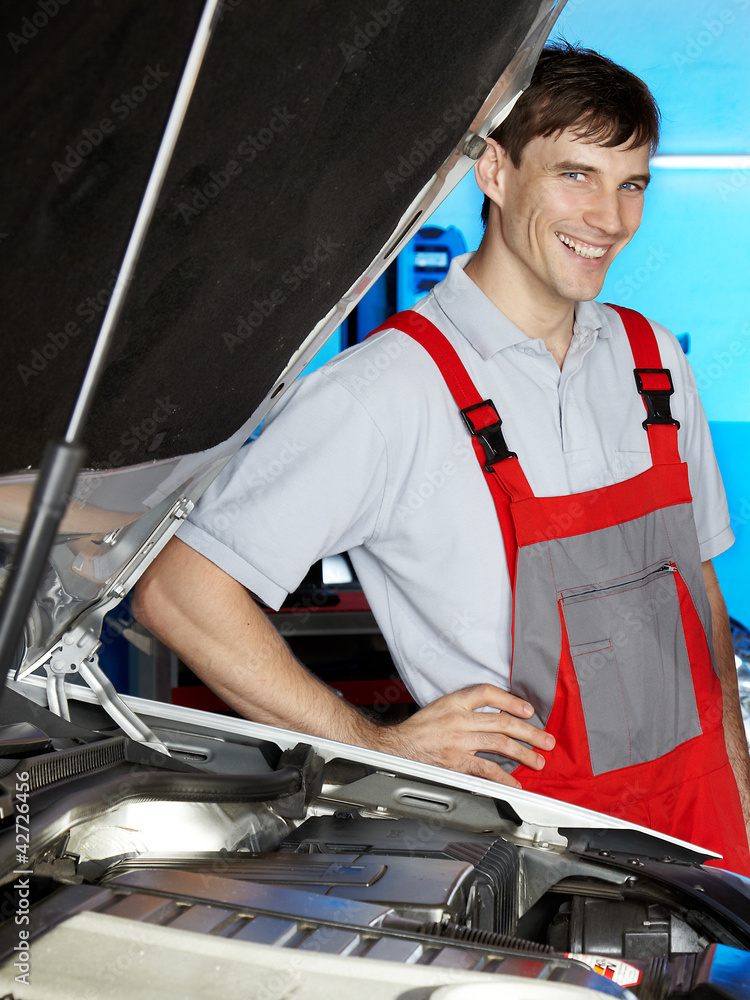 Motor mechanic is fixing the engine of a car in a garage Stock Photo ...