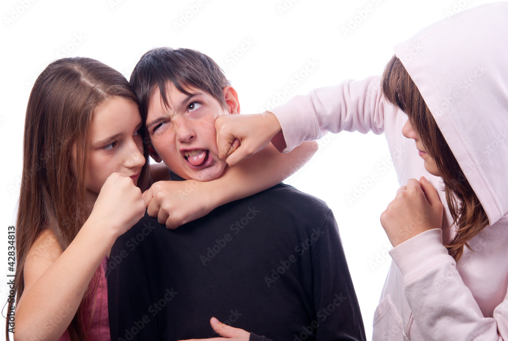 Two teenage girls beating teenage boy Stock Photo | Adobe Stock