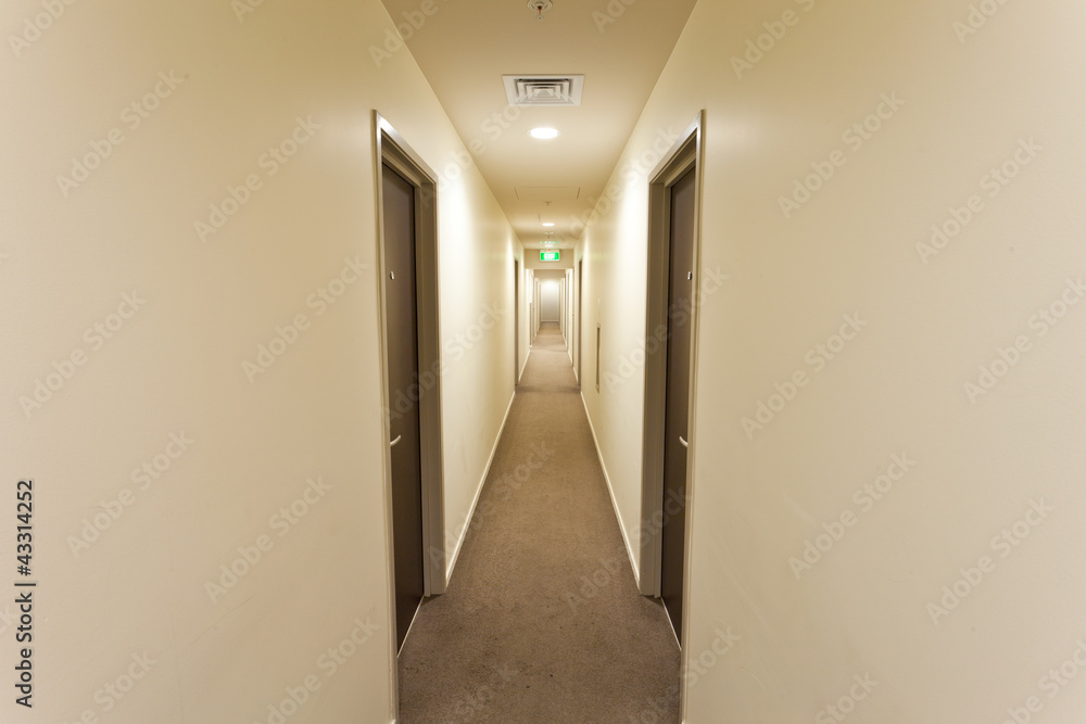 Long corridor with hotel room doors and exit sign Stock Photo | Adobe Stock