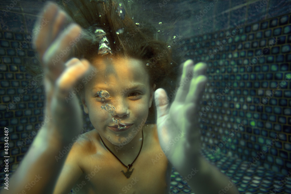 Boy swimming underwater in swimming pool Stock Photo | Adobe Stock