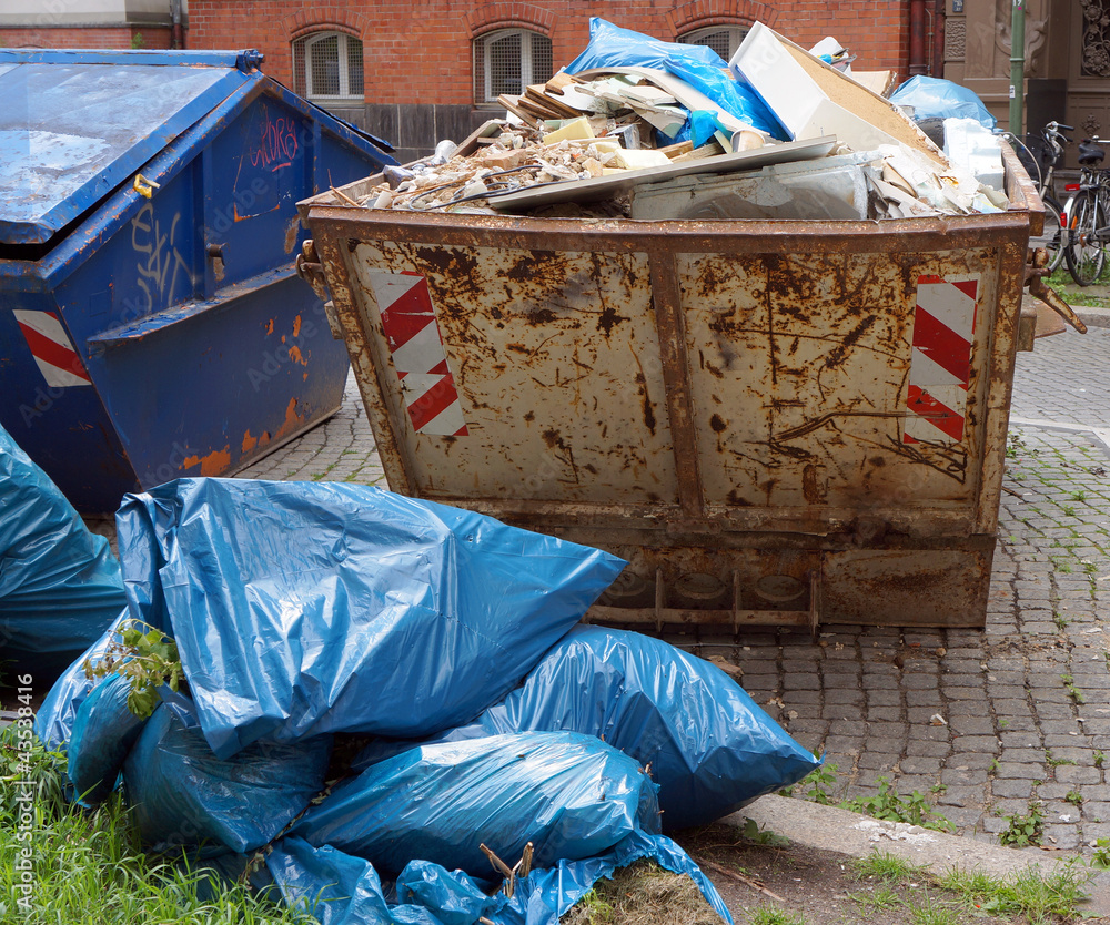 Müll-/Baucontainer mit Müllsäcken davor Stock-Foto | Adobe Stock