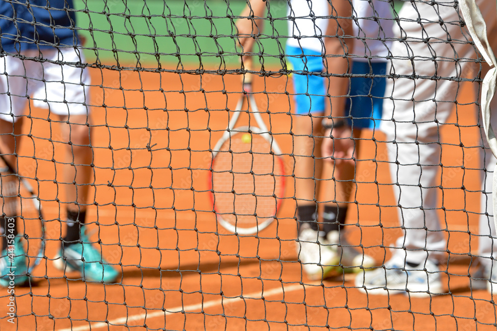Feet and rackets on a tennis court behind network Stock Photo | Adobe Stock