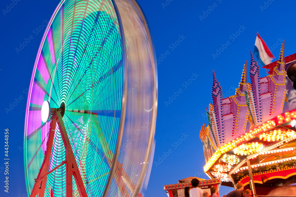 The Circular Motion Of A Ferris Wheel Blurs At Twilight Stock Photo the-circular-motion-of-a-ferris-wheel-blurs-at-twilight-stock-photo