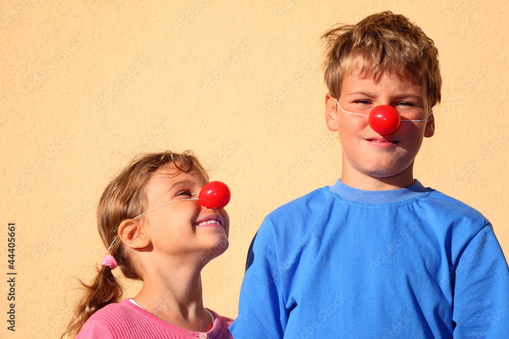 Brother and sister with red clown noses stand near wall Stock Photo ...
