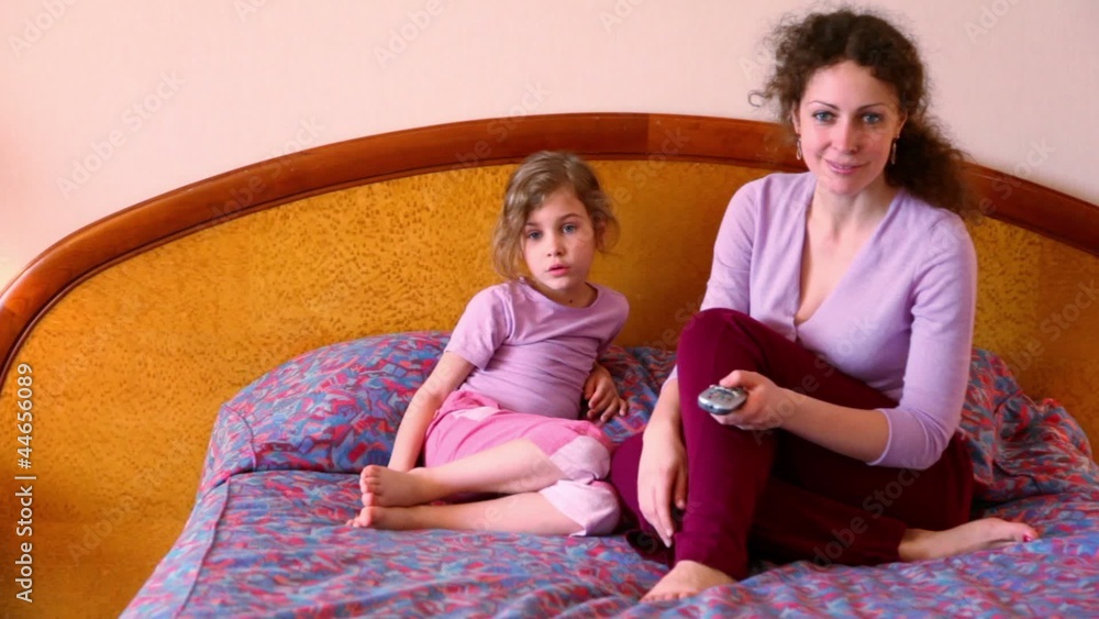 Mother And Daughter Sit On Bed And Watch Tv Stock ビデオ Adobe Stock