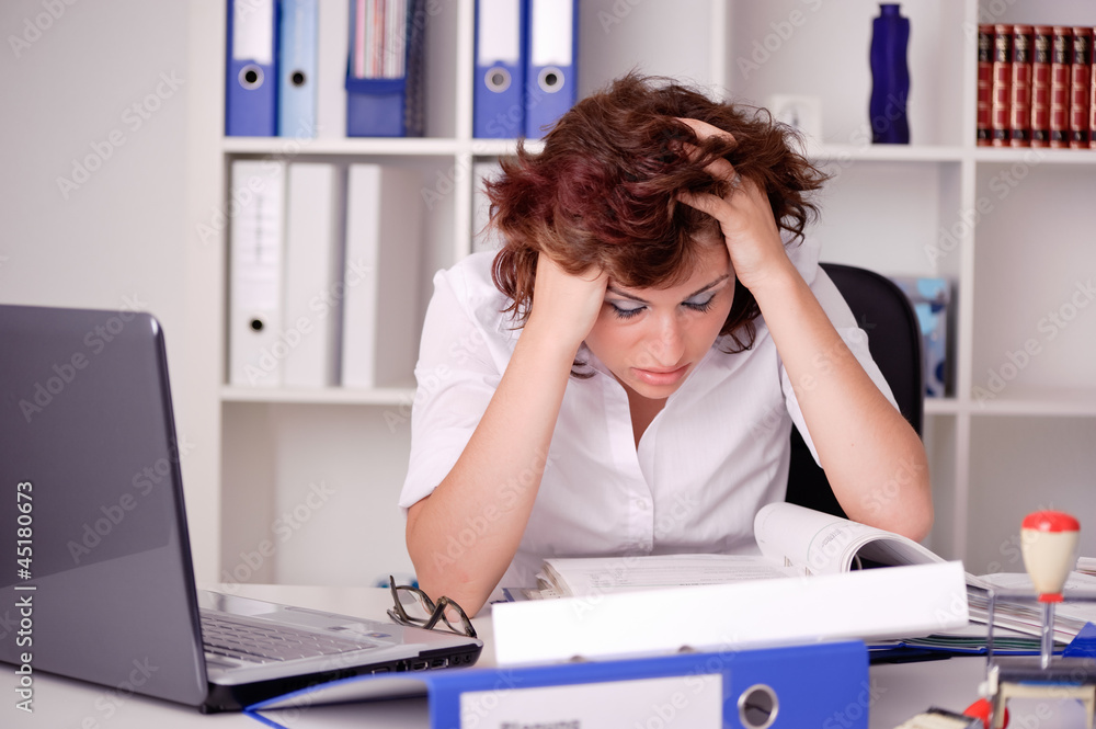 Gestresste junge Frau am Schreibtisch Stock-Foto | Adobe Stock