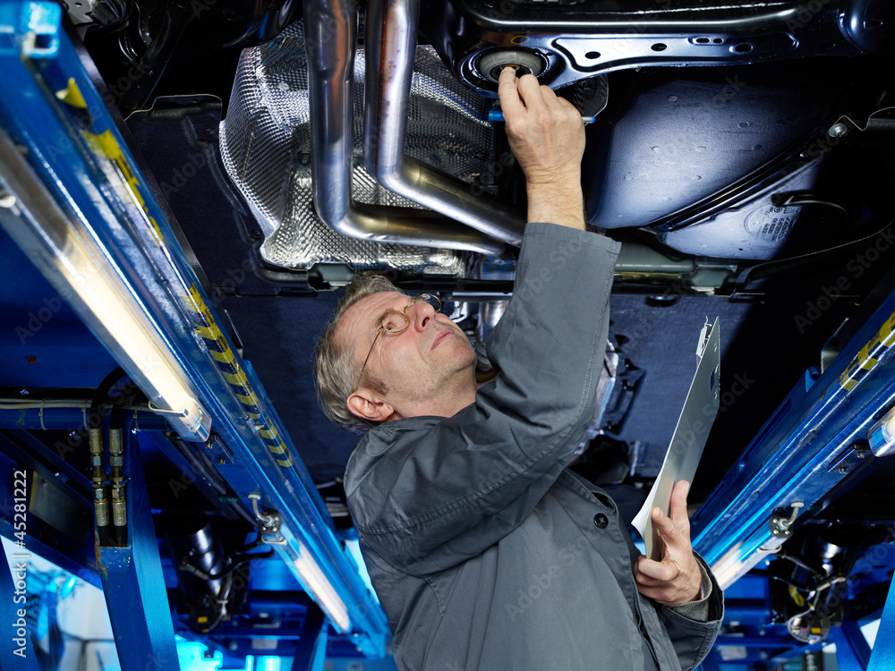 Master mechanic is checking the engine bay on a service lift Stock ...