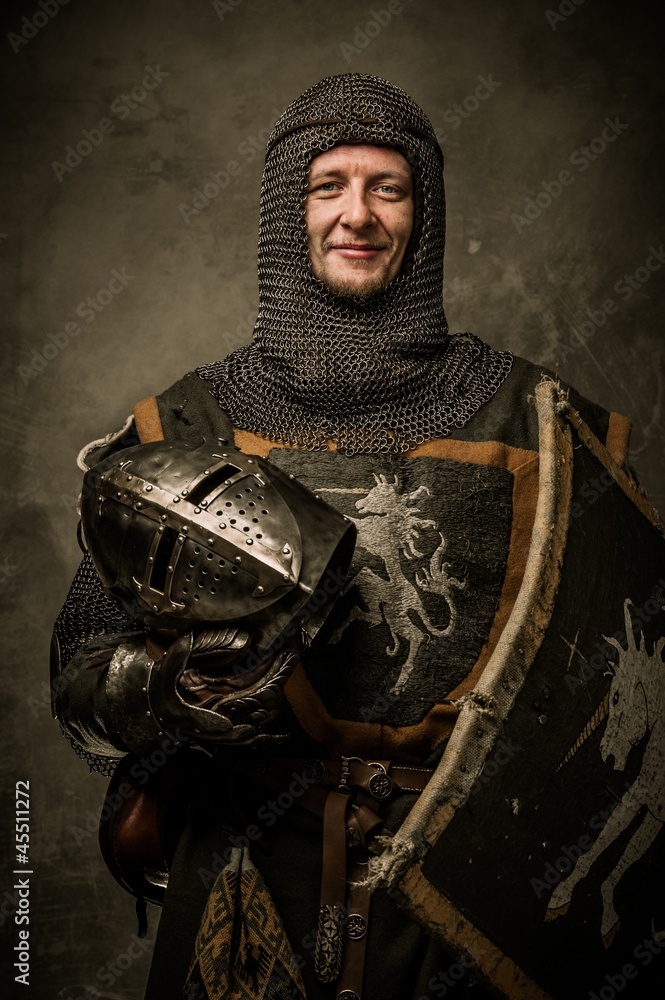 Smiling medieval knight holding helmet Stock Photo | Adobe Stock