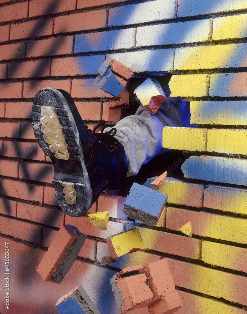 Pateando y rompiendo un muro de ladrillos. Stock Photo | Adobe Stock