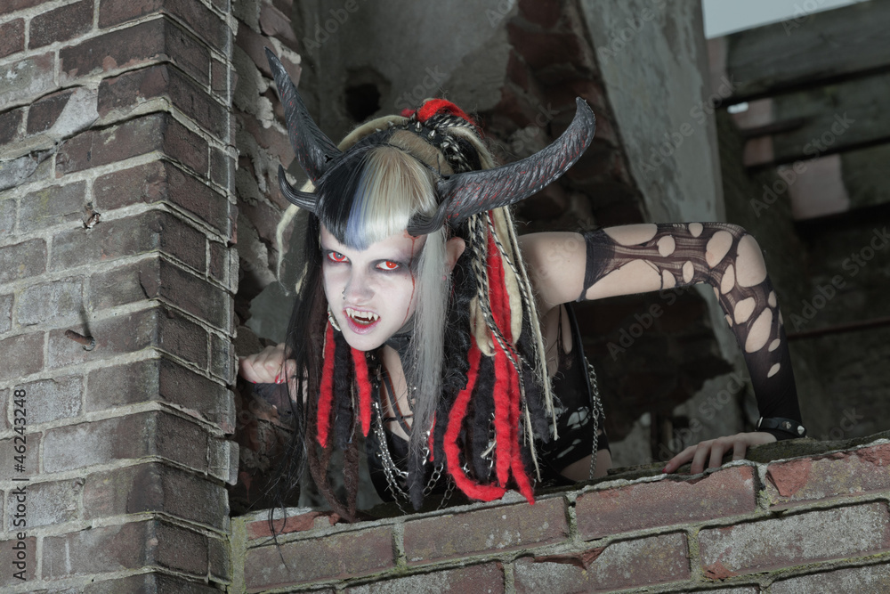 Scary hungry female demon crawling over old dirty wall. Stock Photo | Adobe Stock